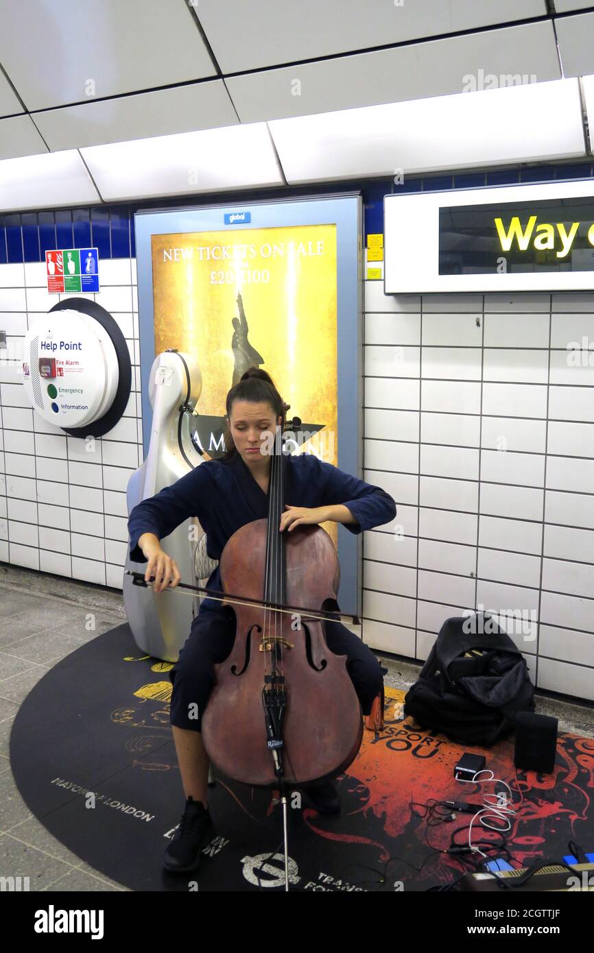A woman professional musician busking in Piccadilly underground station ...