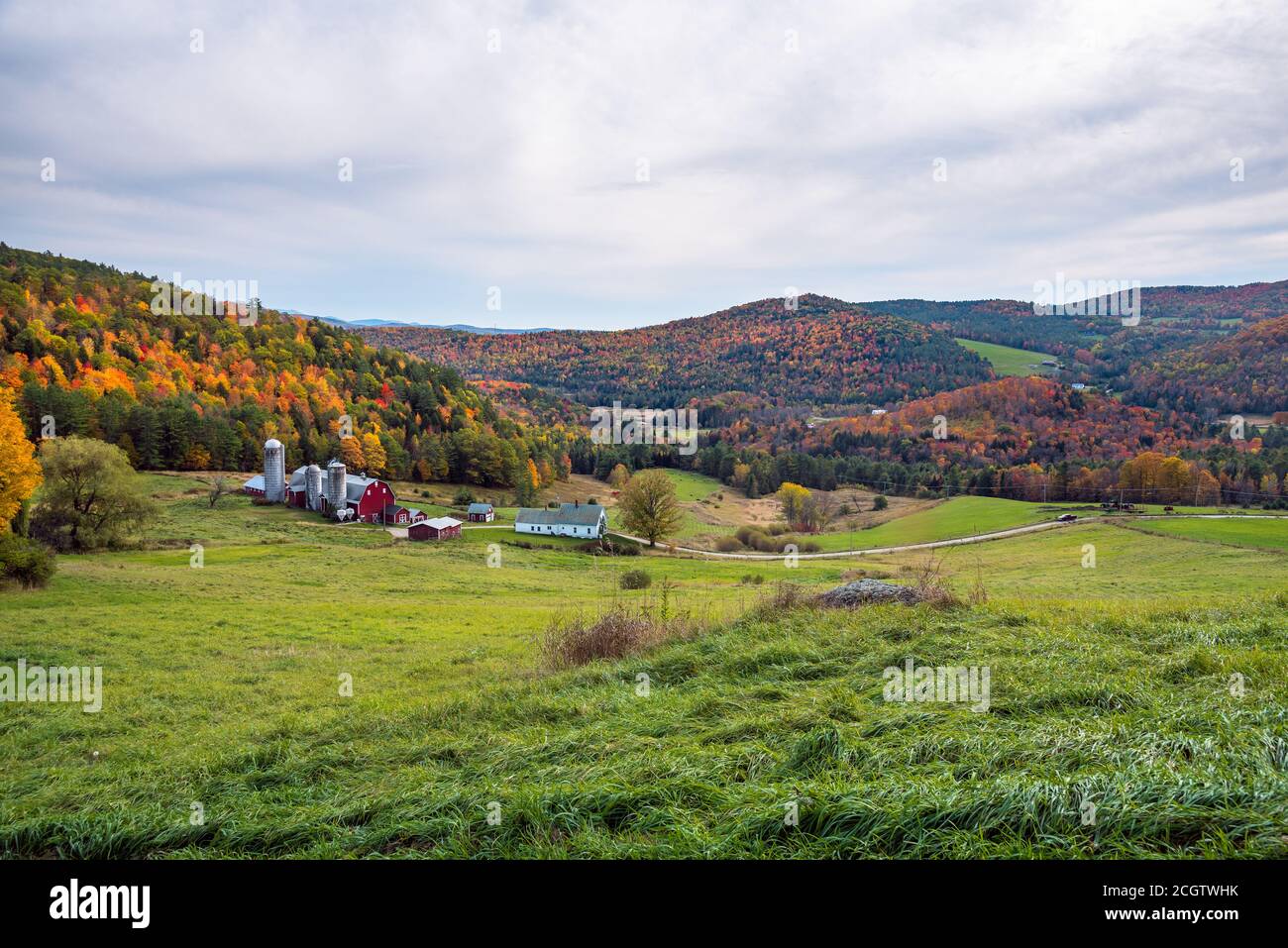Farm in a rolling rula landscape with wooded hills at the peak of fal ...