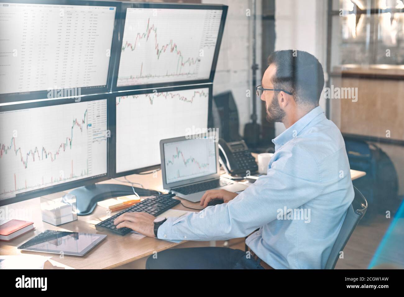 Stock Traiding. Trader sitting at office monitoring changes of ...