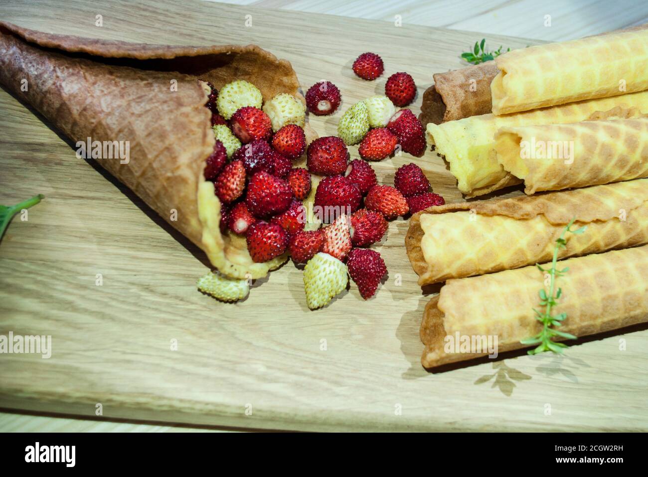 Golden waffle cone filled with white and red strawberries and many ...
