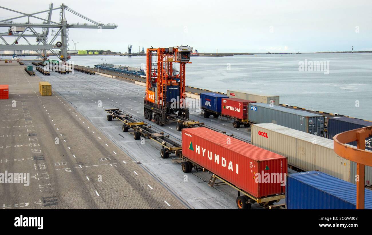 Straddle carrier moving a Maersk container in the shipping terminal of ...