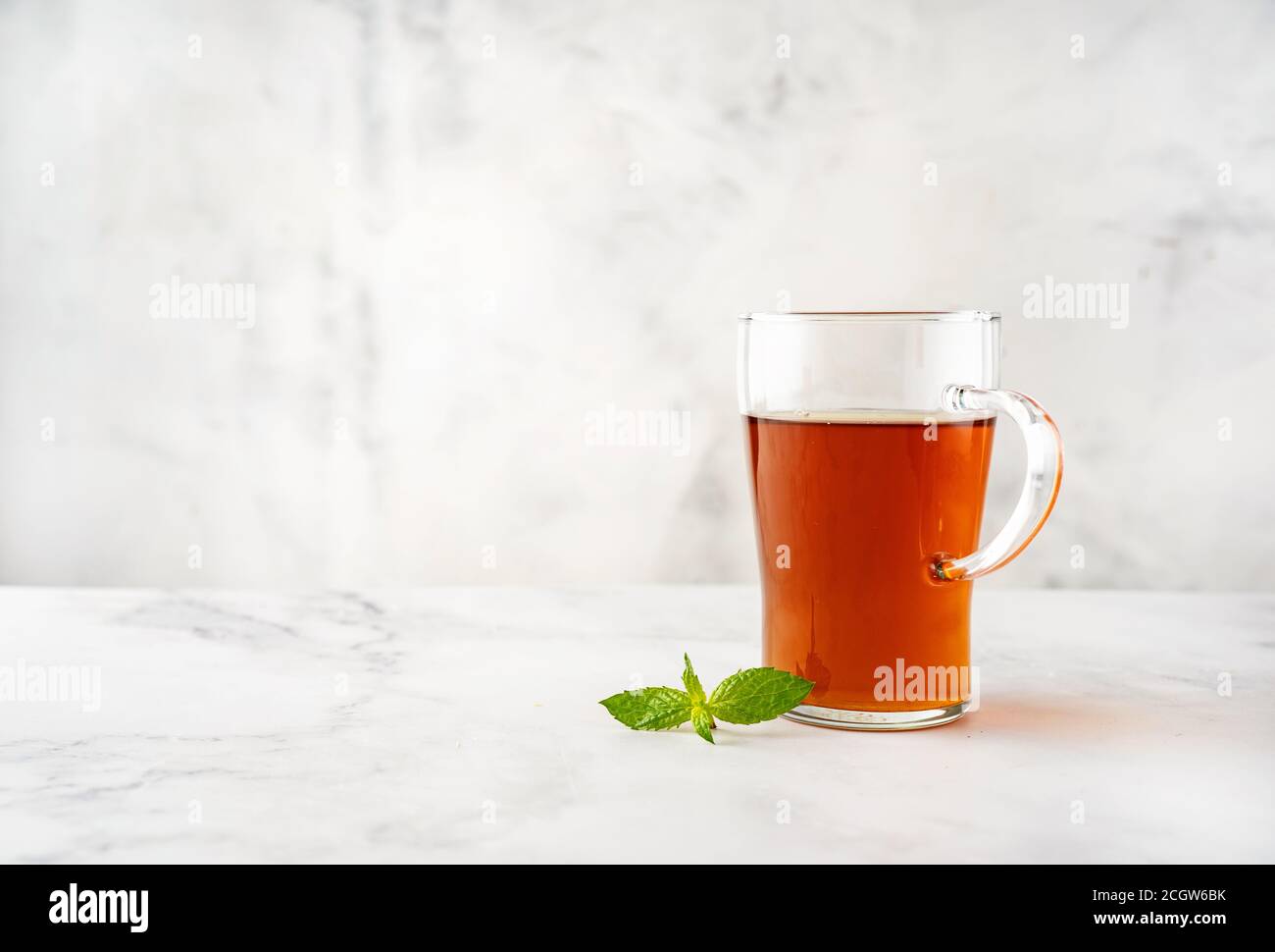 Single glass cup of tea on white background wiht copy space. Whinter ...