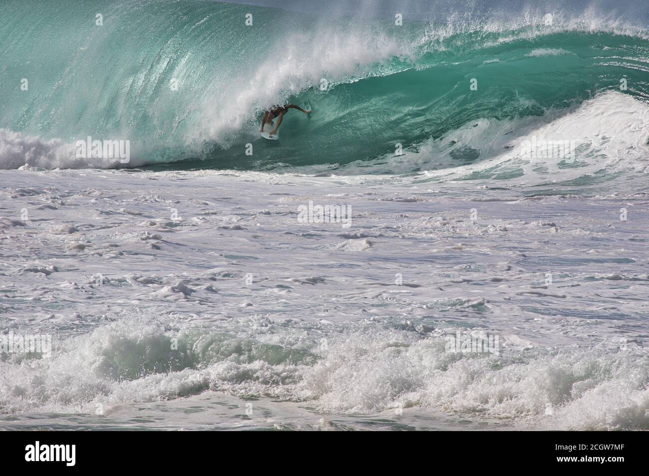 unrecognizable surfer riding inside the curl of a north shore, oahu ...