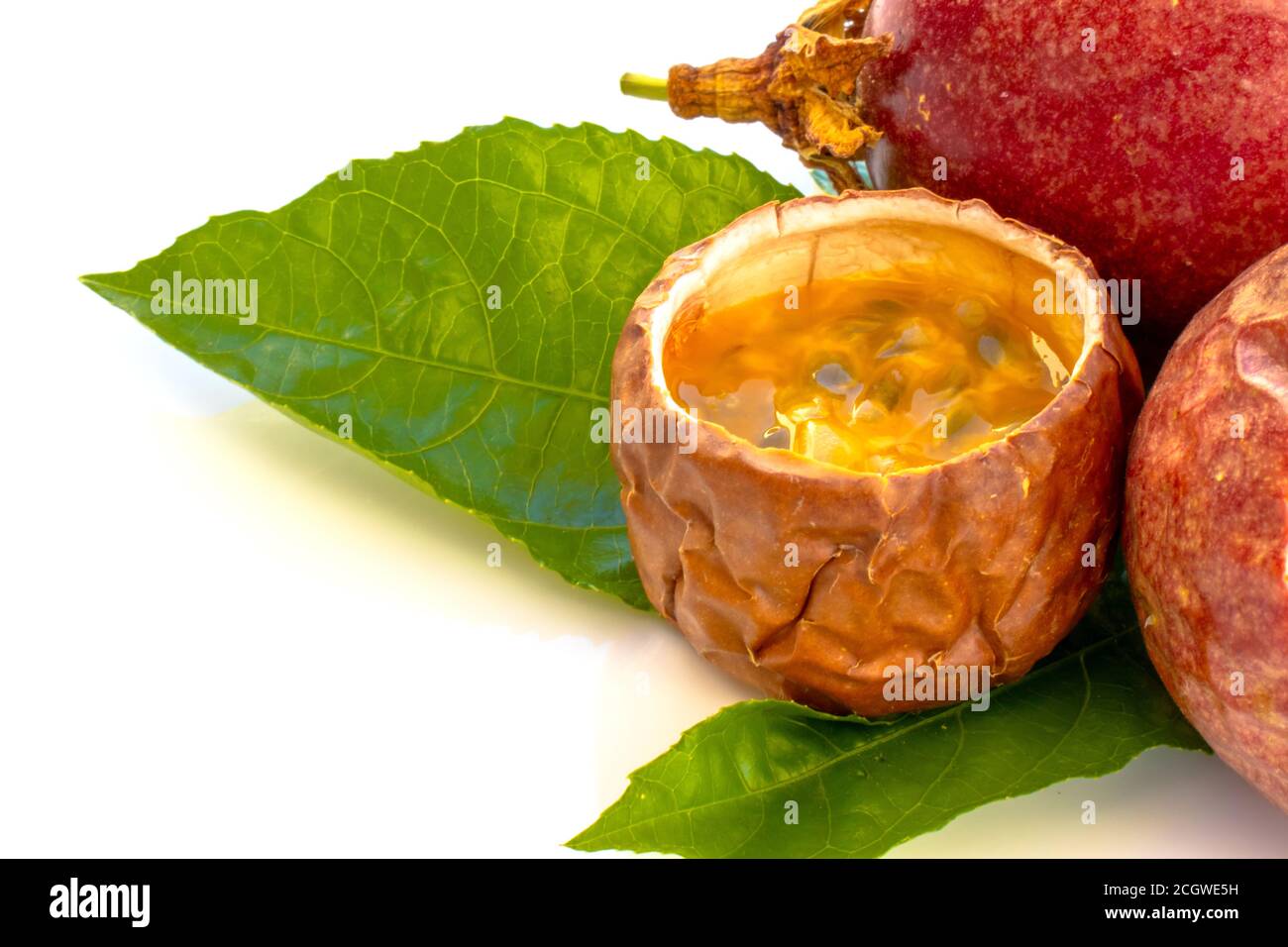 Maracuja cut in half and whole in small glass container peel of the ...