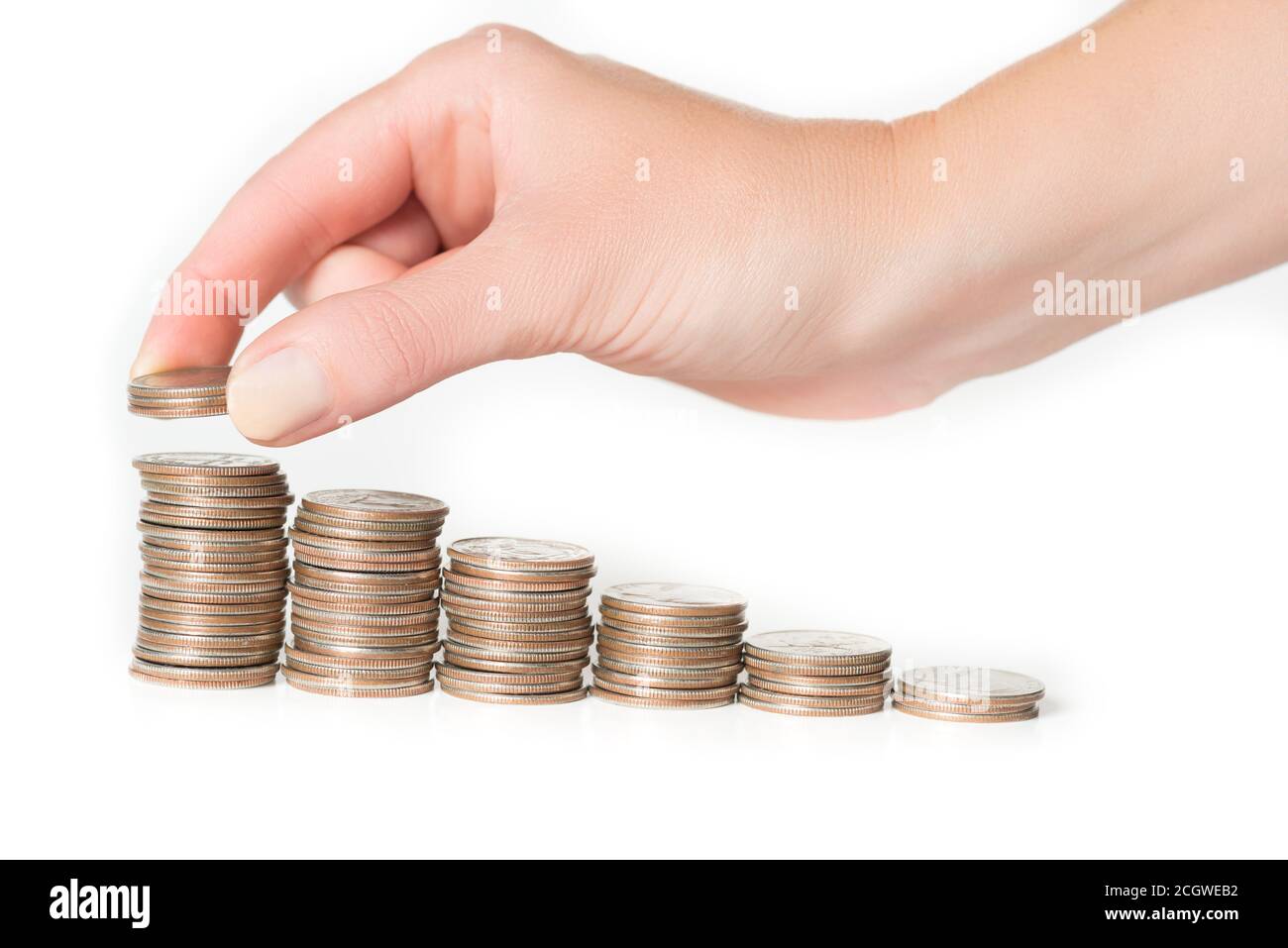 Woman hand stacking US quarters into increasing columns on a white ...