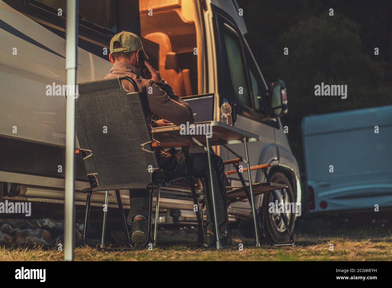 Caucasian Men Working on His Laptop Computer Next to His RV Motorhome ...