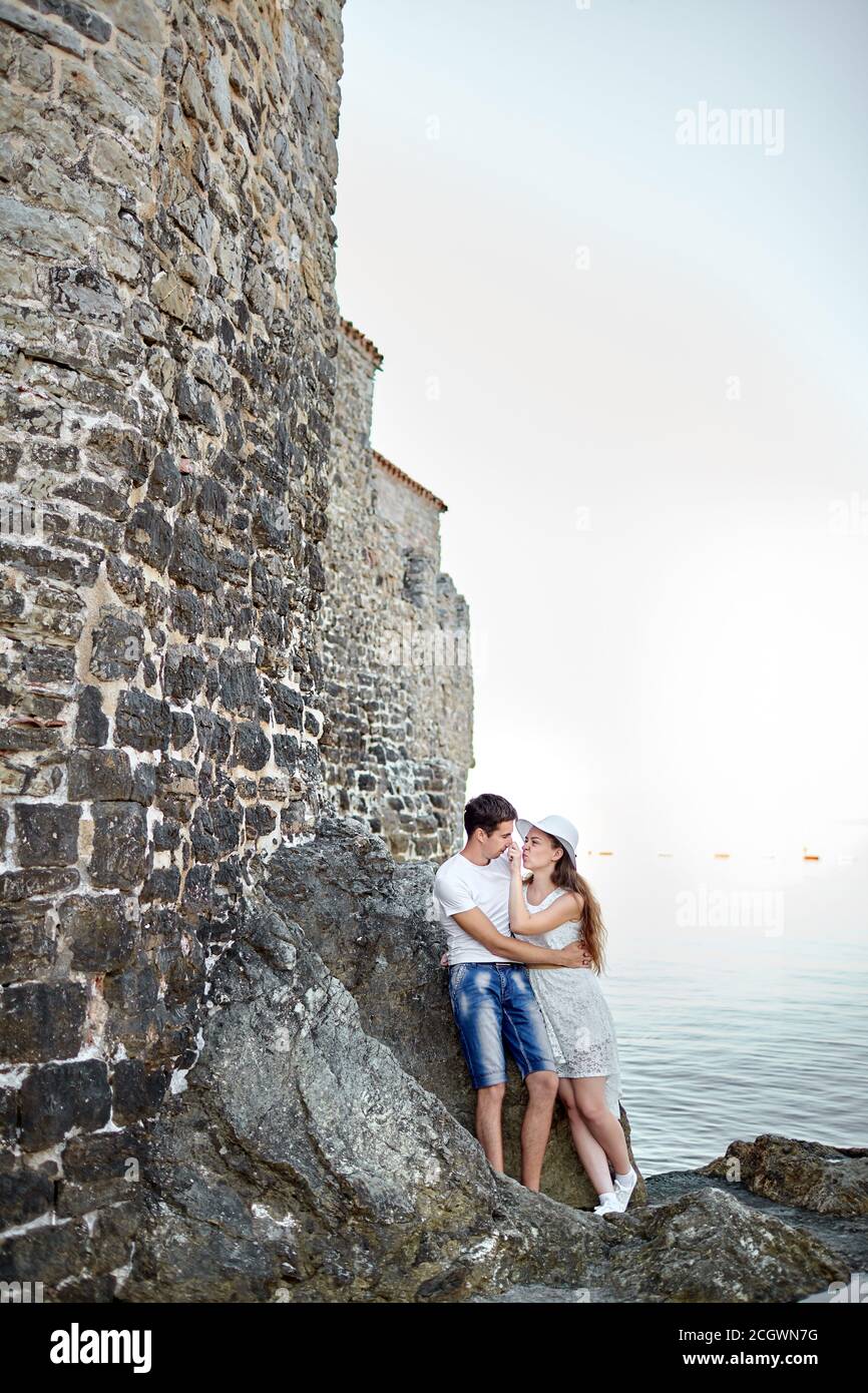 Couple in love hugging on the rocks against the background of an old ...