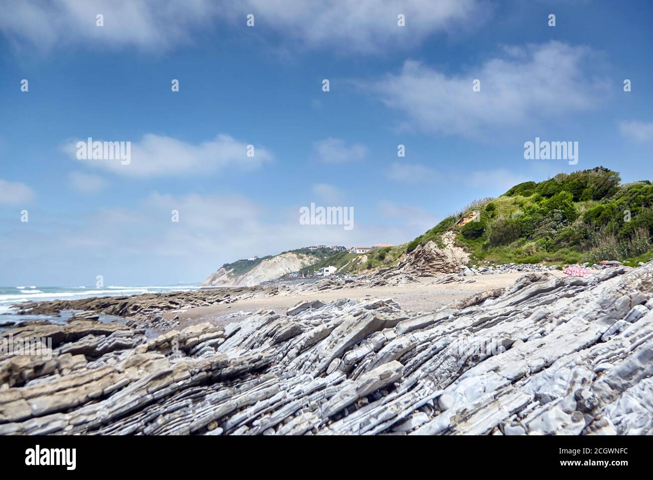 Beach of Bidart, France. Sharp stones and ocean water. Sunny summer day ...
