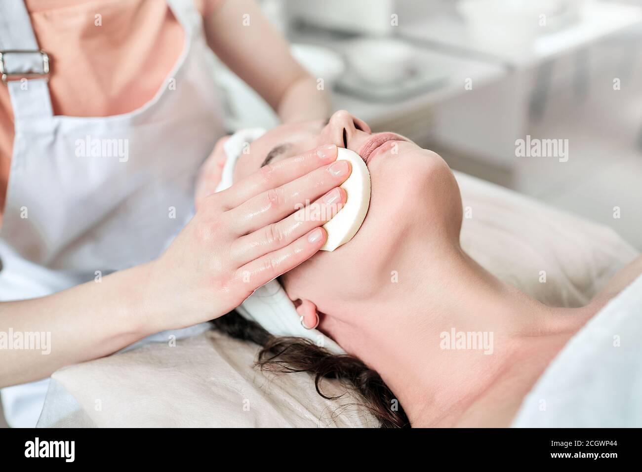 Hands of female beautician with facial cleansing sponge. Skin care ...