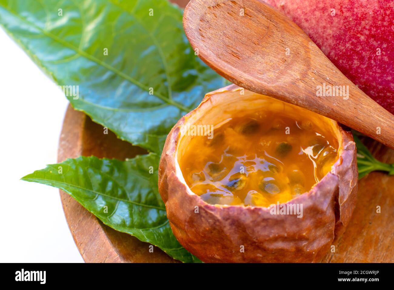 Maracuja cut in half and whole in small glass container peel of the ...