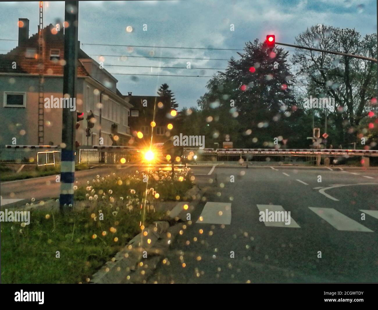 Closed barriers of a railroad crossing in the rain Stock Photo - Alamy