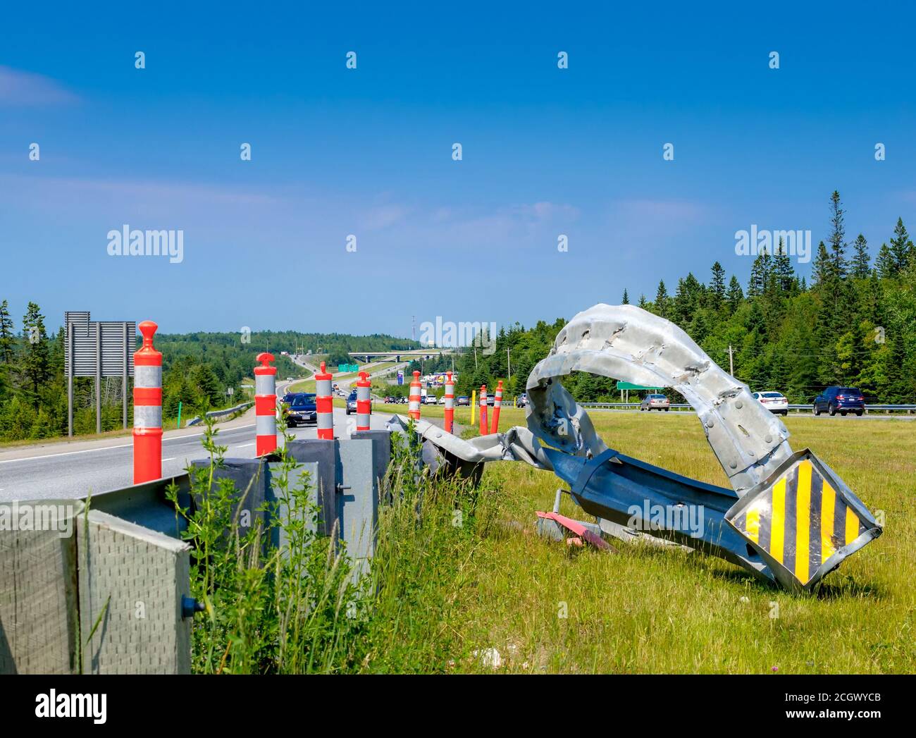 A bent and twisted guard rail at the side of a highway.It appears to ...