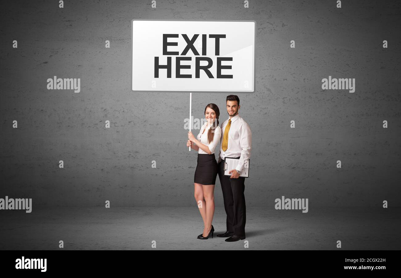 business person holding a traffic sign with EXIT HERE inscription, new ...