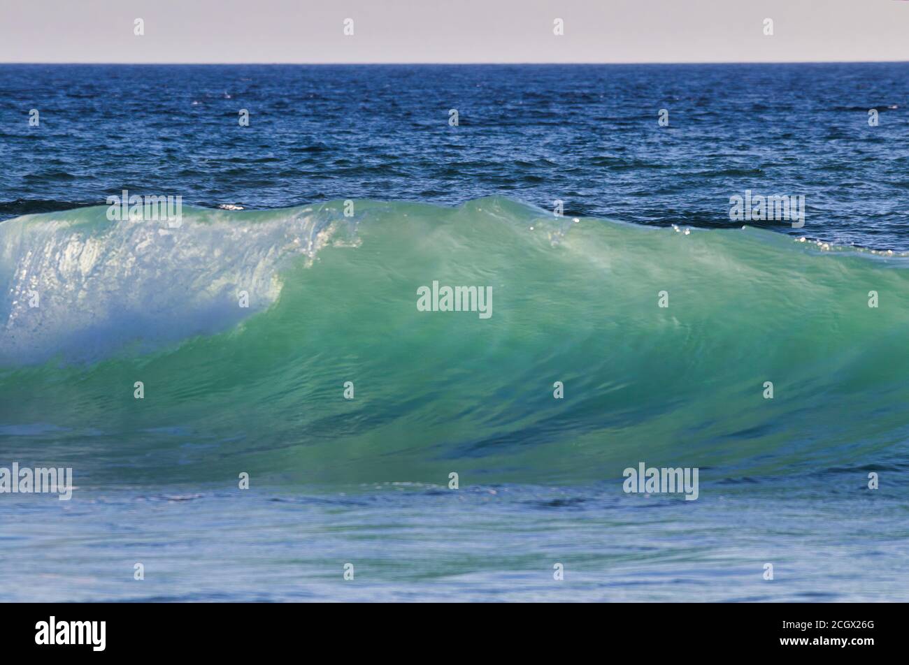 Crystal clear aquamarine wave breaking Stock Photo - Alamy