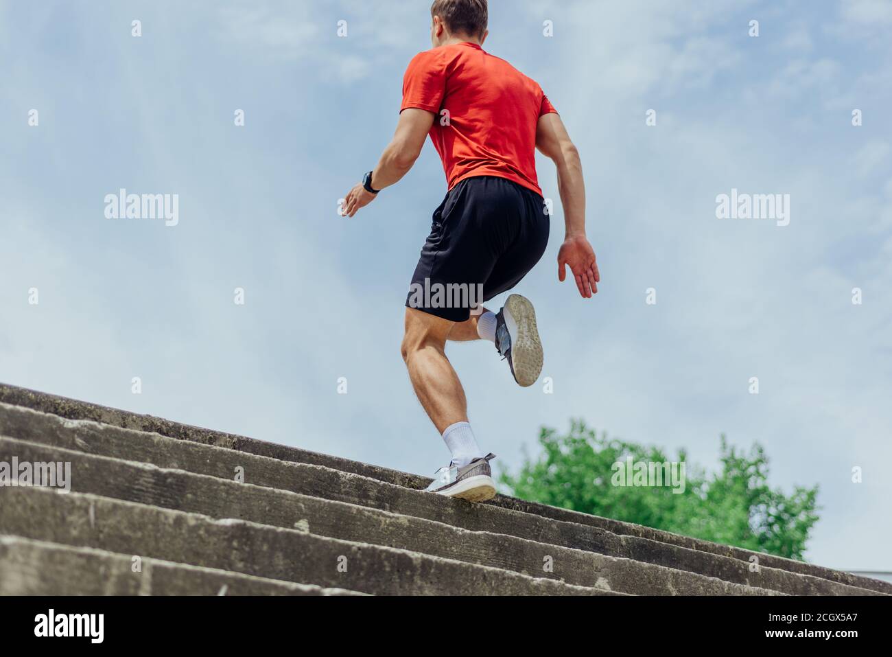Fit male athlete performing stairs workout, running up climbing stairs ...