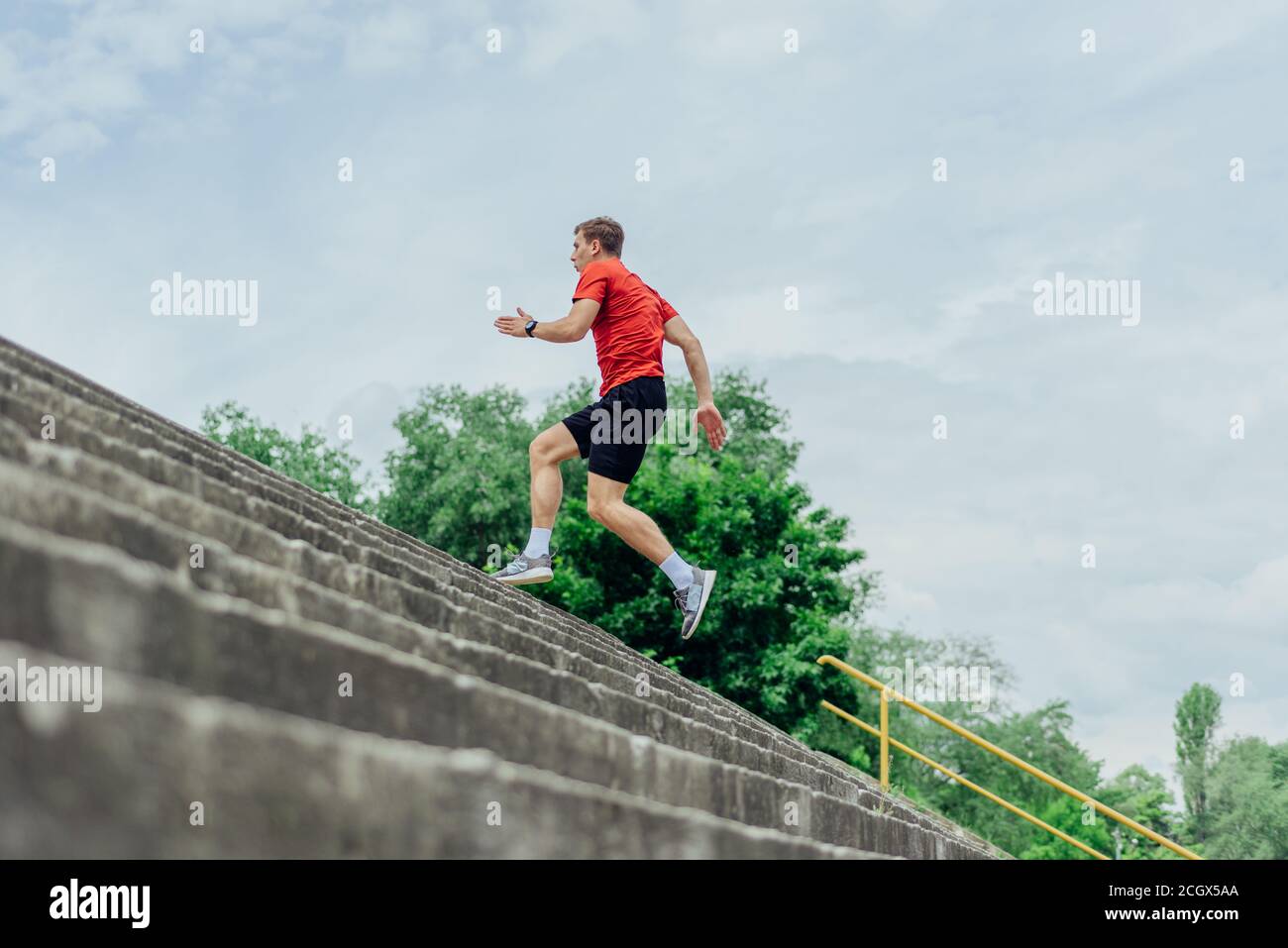Fit male athlete performing stairs workout, running up climbing stairs ...