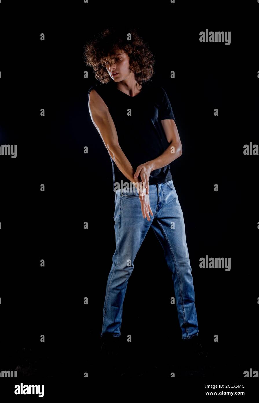 Skinny rock guy wearing blue jeans pants isolated on black backgorund ...