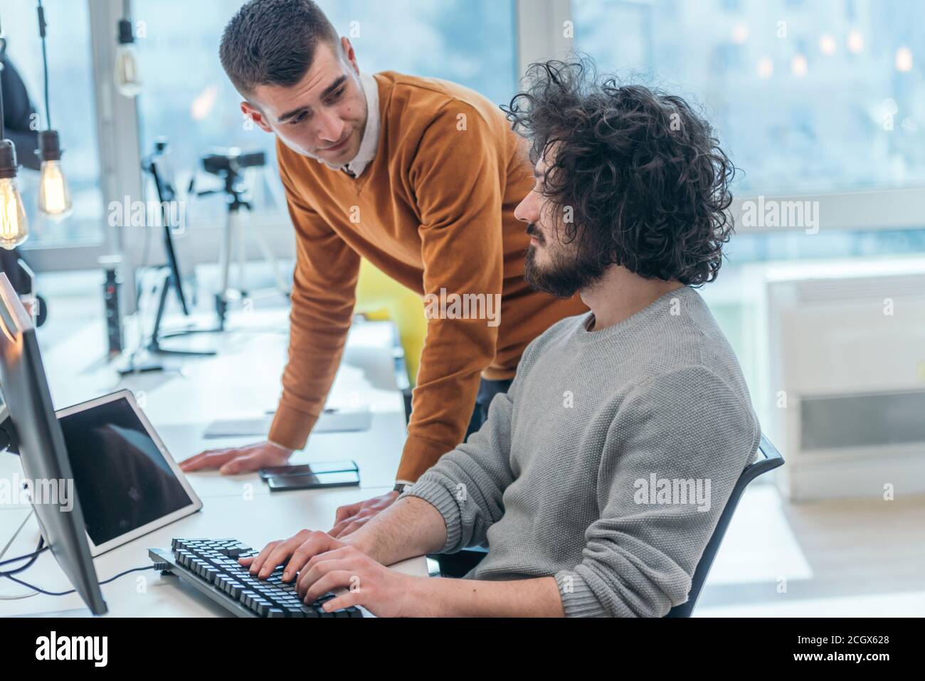 Portrait of two busy colleagues working on pc economy project on modern ...