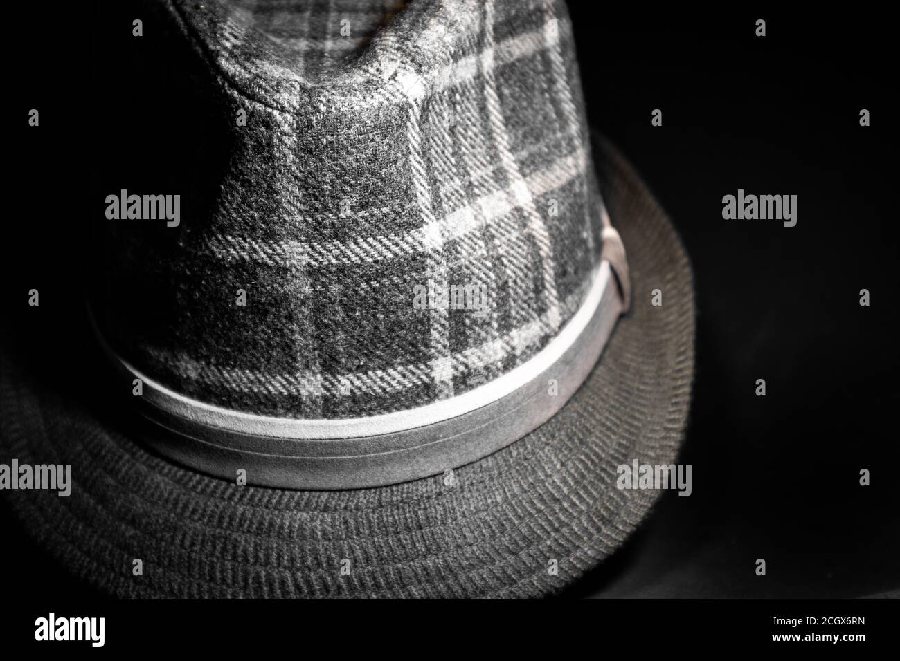 High contrast shot of gray fedora on left half of screen with blank ...
