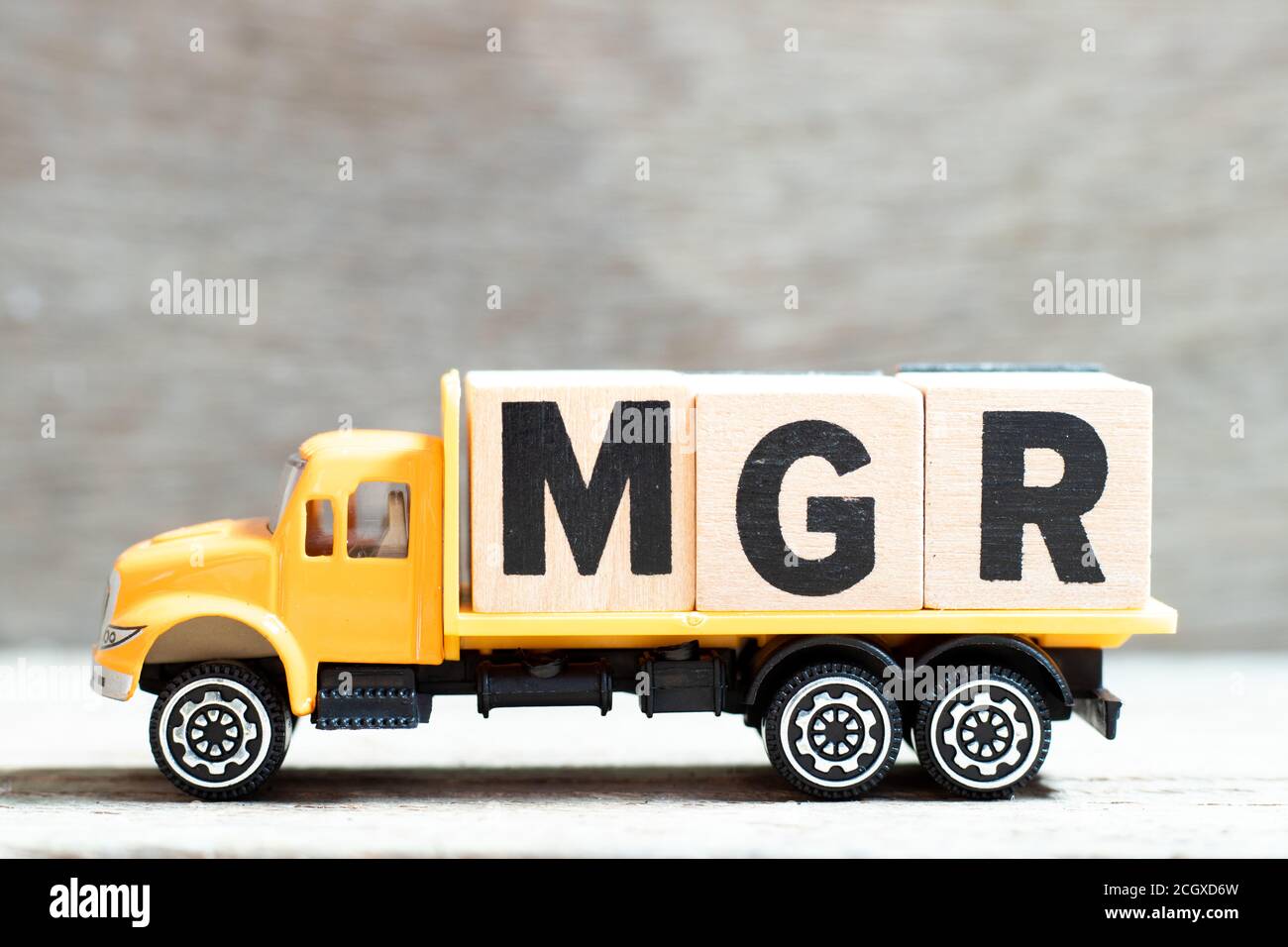 Truck hold letter block in word mgr (abbreviation of manager) on wood ...