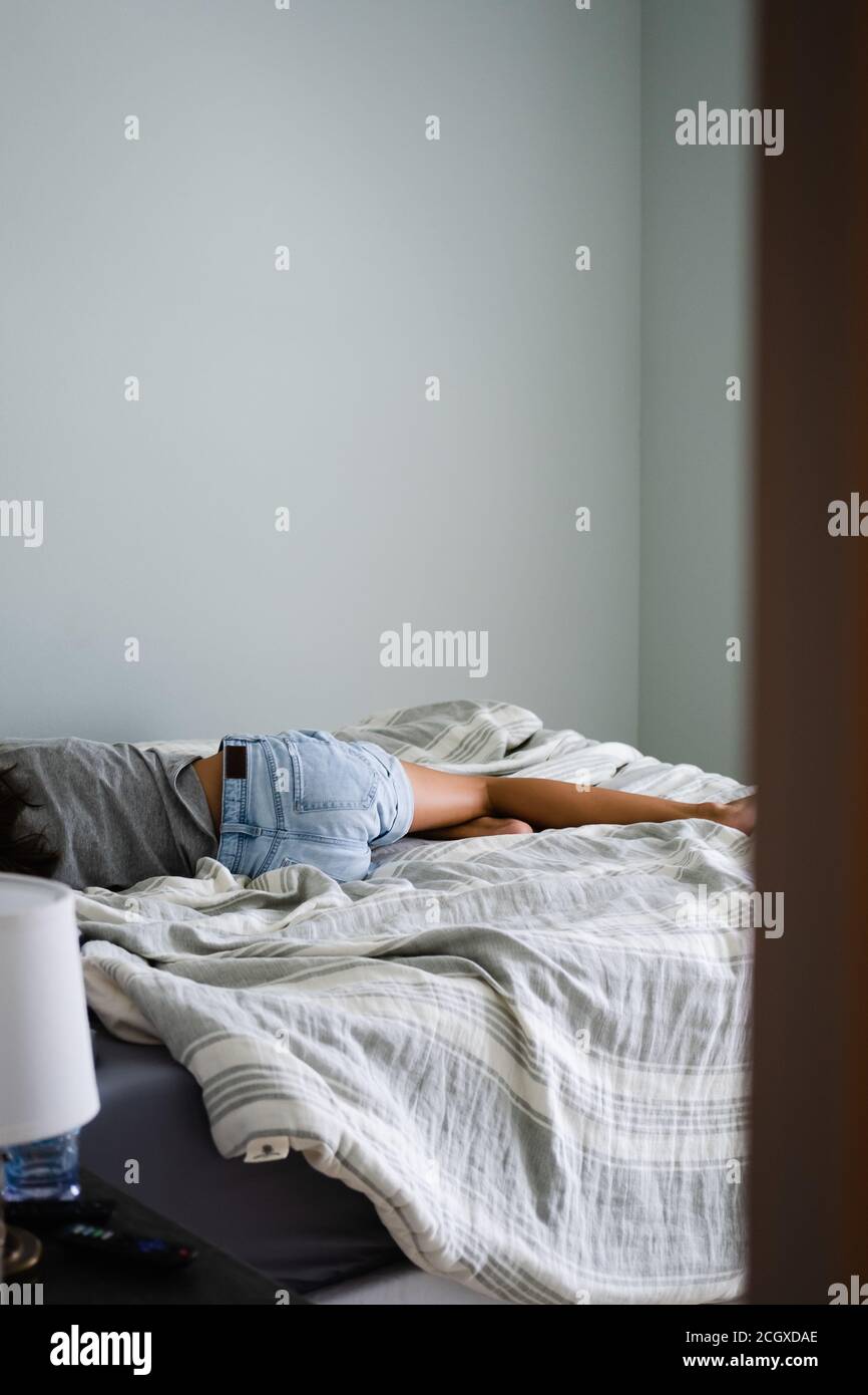 Faceless young girl resting on a bed Stock Photo - Alamy
