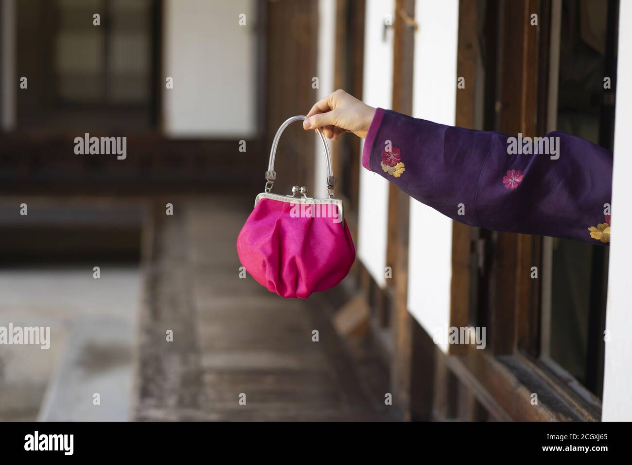 Woman in Korean traditional clothes holding Korean traditional pouch ...
