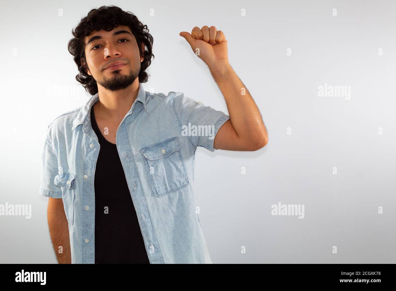 young hispanic deaf man using sign language to communicate, on a white background wearing casual ...