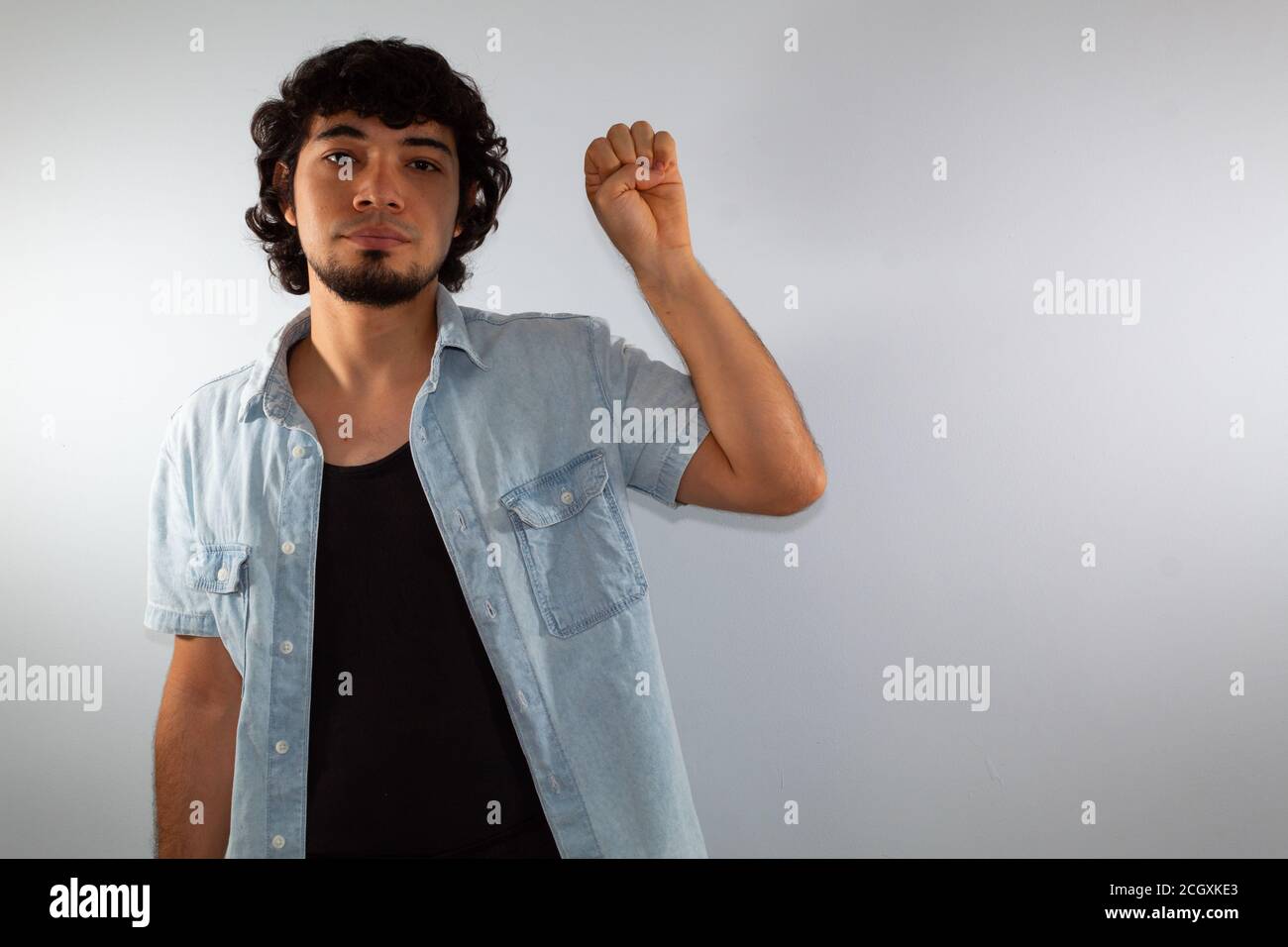 young hispanic deaf man using sign language to communicate, on a white background wearing casual ...