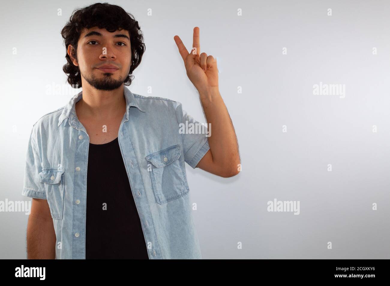 young hispanic deaf man using sign language to communicate, on a white ...