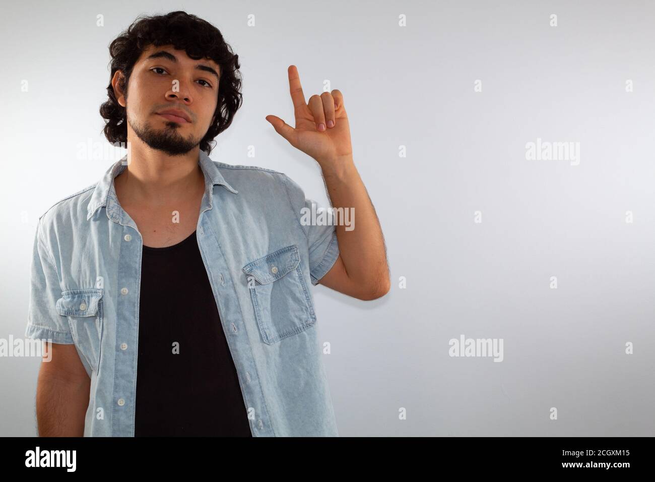 young hispanic deaf man using sign language to communicate, on a white ...