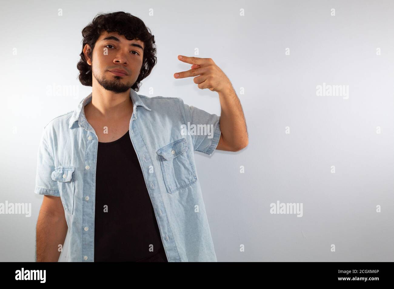 young hispanic deaf man using sign language to communicate, on a white ...