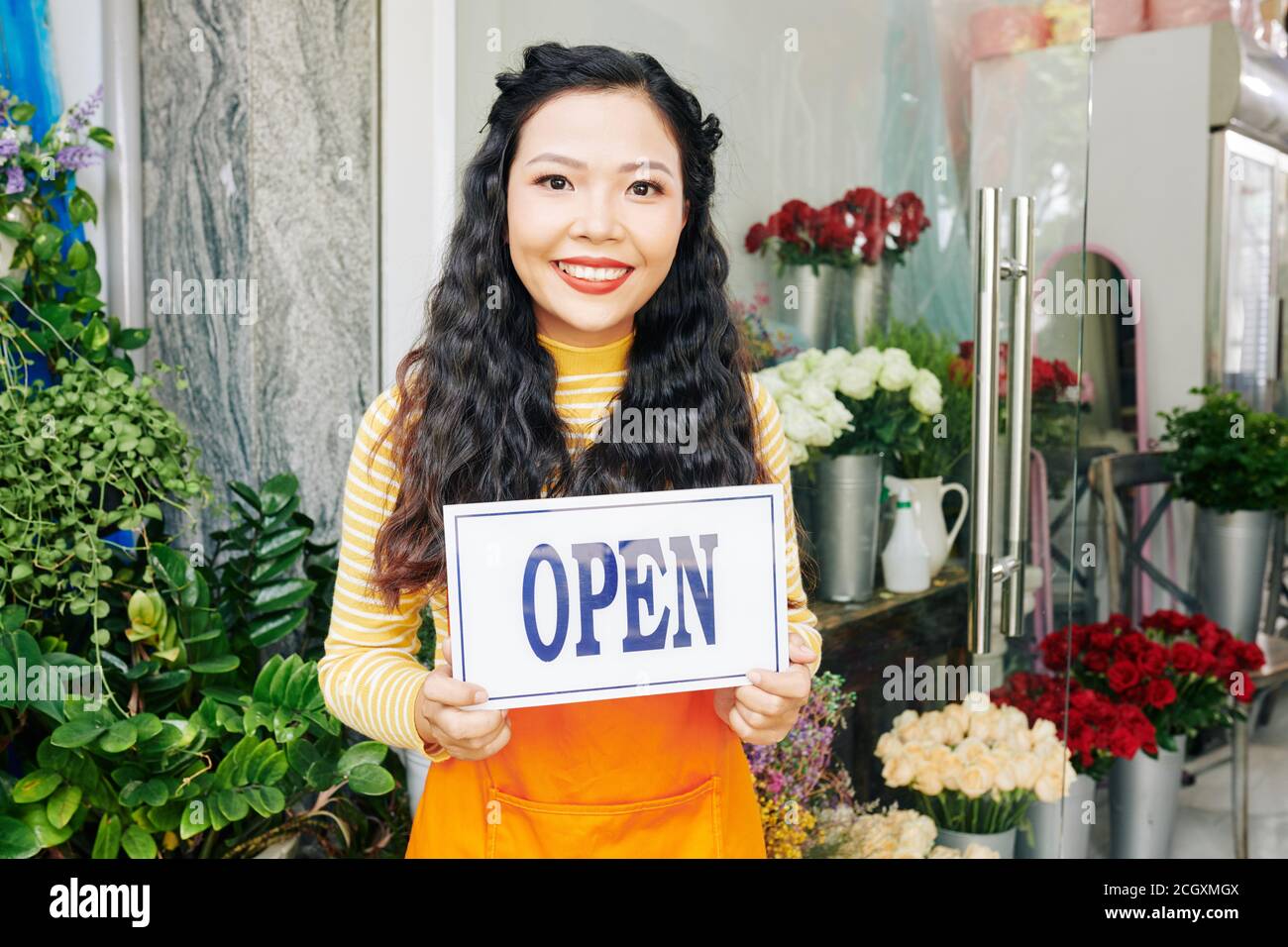 Flower shop owner with open sign Stock Photo - Alamy