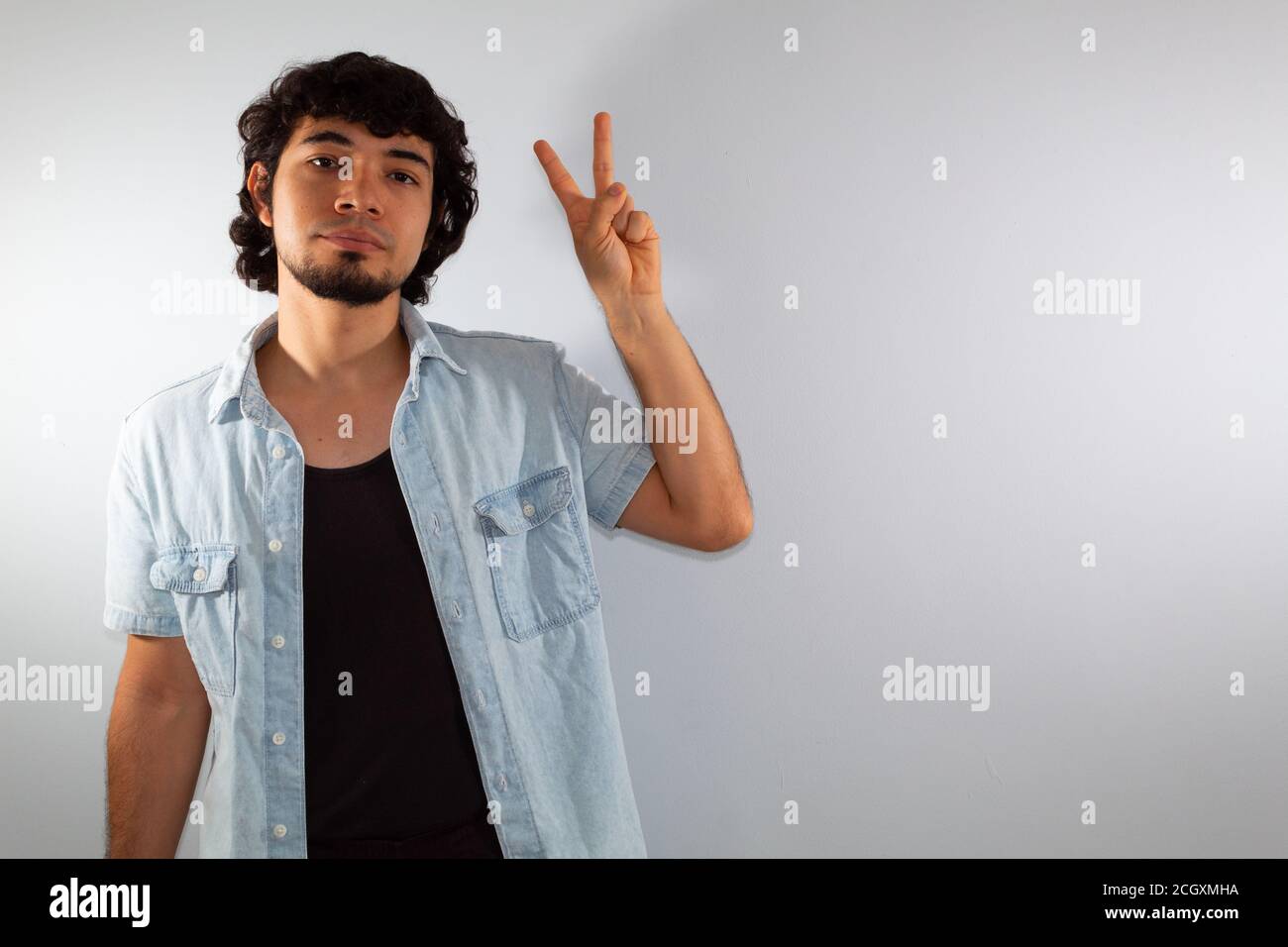 young hispanic deaf man using sign language to communicate, on a white ...