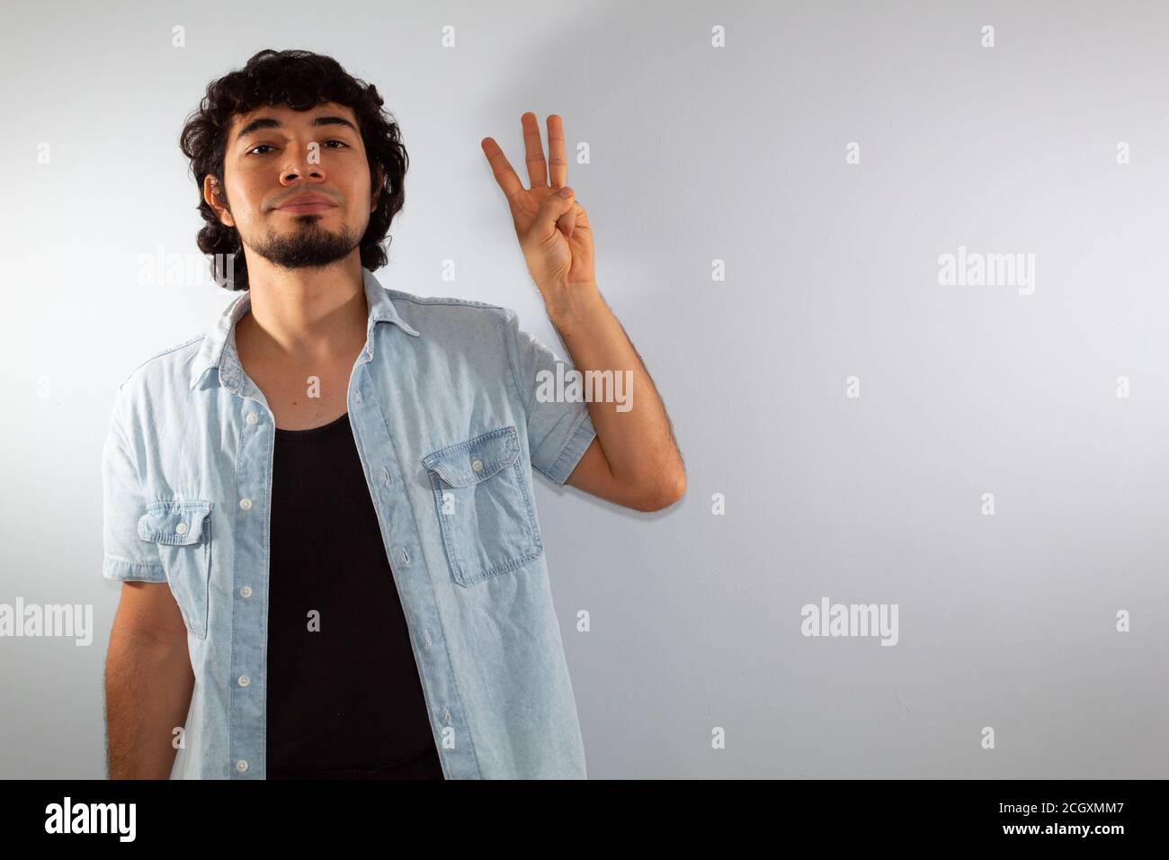 young hispanic deaf man using sign language to communicate, on a white ...