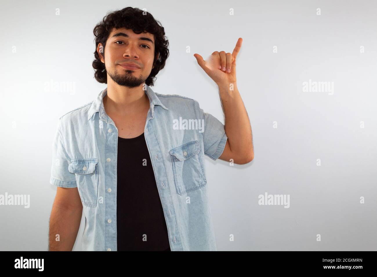 young hispanic deaf man using sign language to communicate, on a white ...