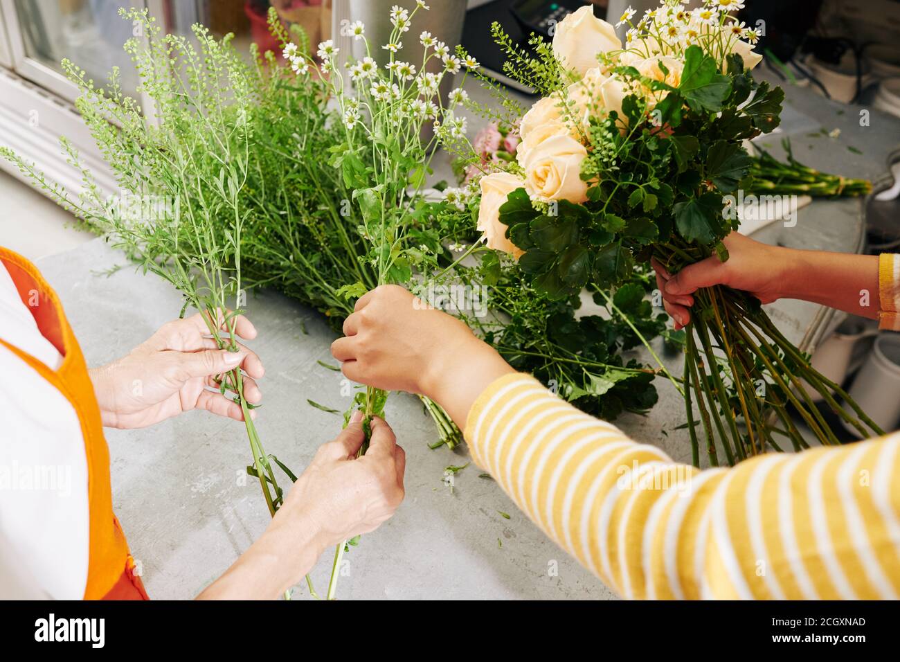Florist and assistant arranging bouquet Stock Photo - Alamy
