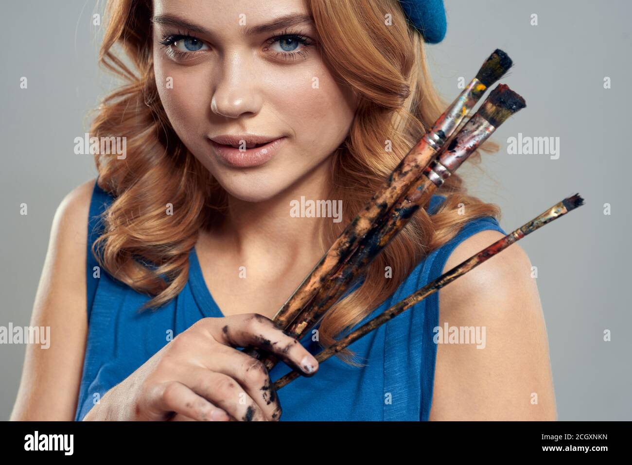 Pretty woman artist paintbrush near face blue beret close-up art Stock ...