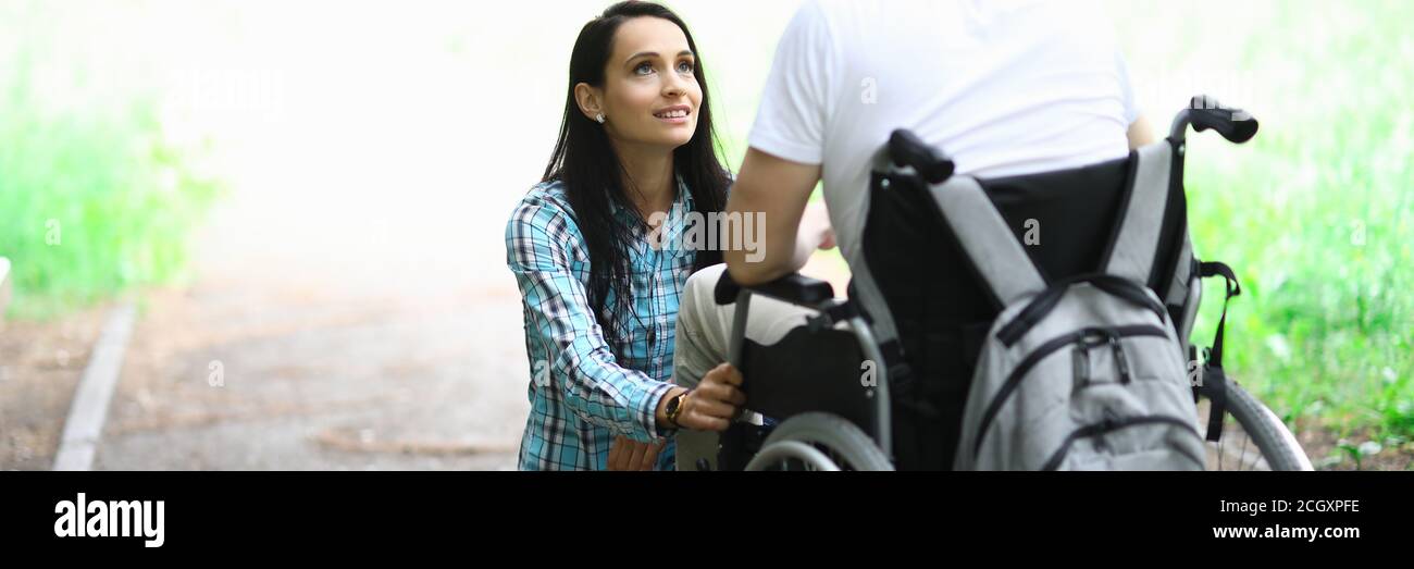 Disabled couple in love on a walk in park portrait. Wife looks at her ...