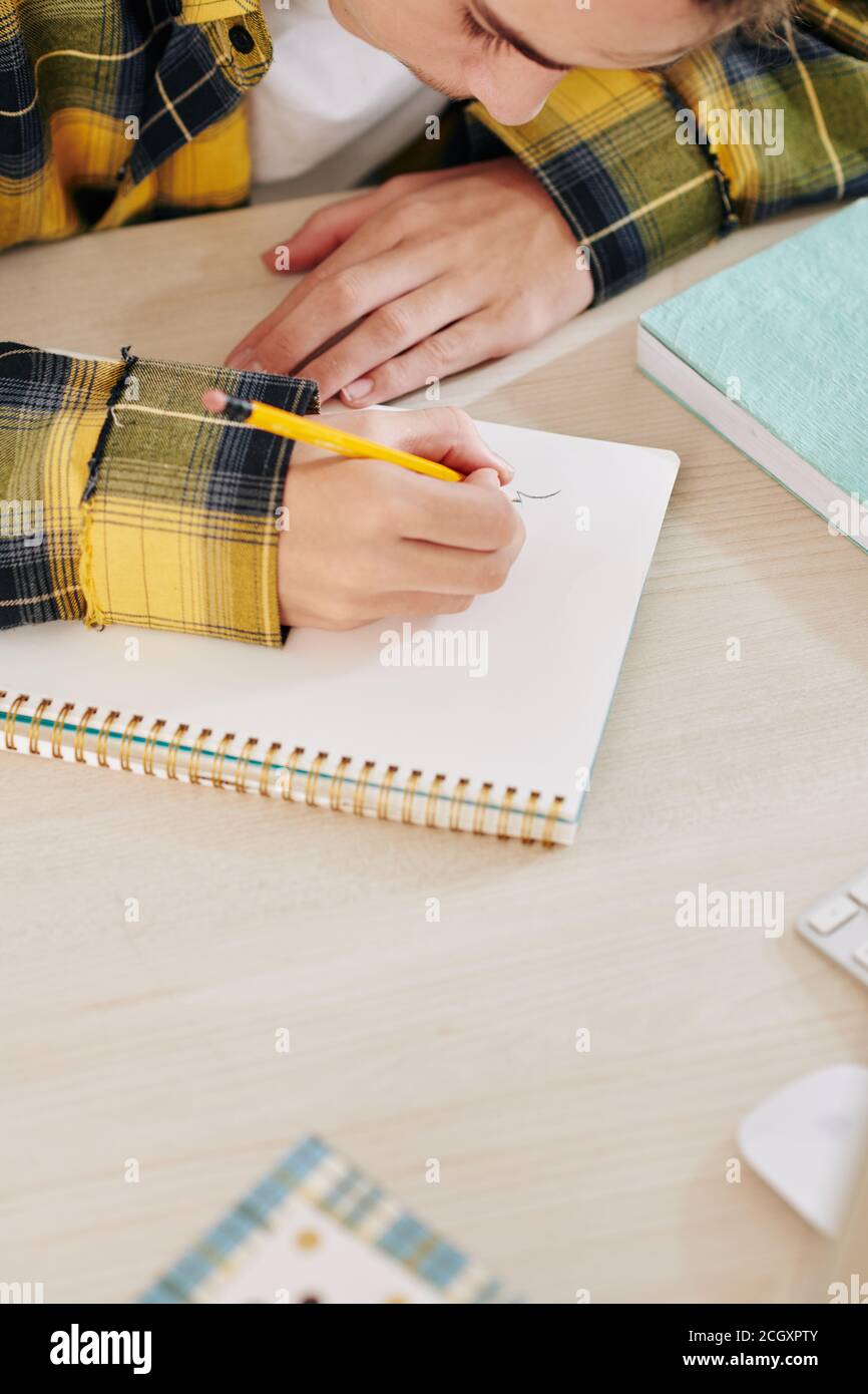 Teenage boy drawing in notebook Stock Photo - Alamy