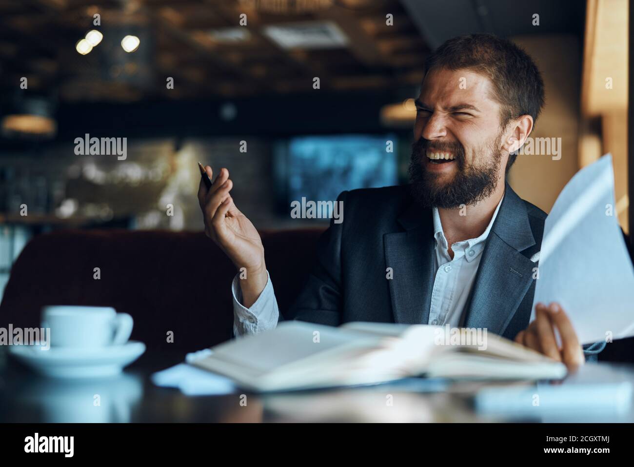 business man sitting at a table in a cafe documents work official ...