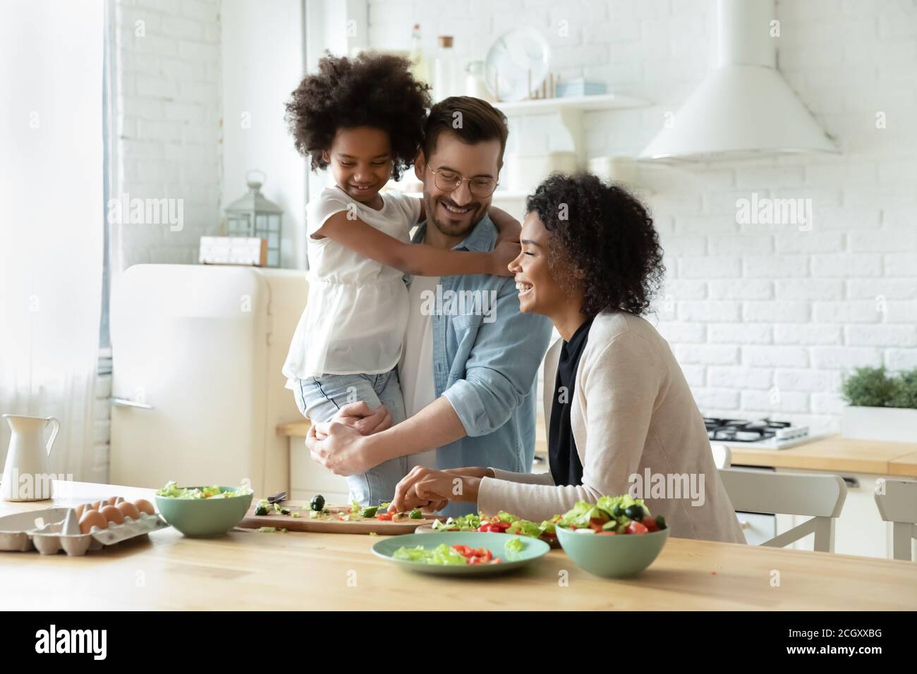 Happy multiracial family involved in cooking process Stock Photo - Alamy