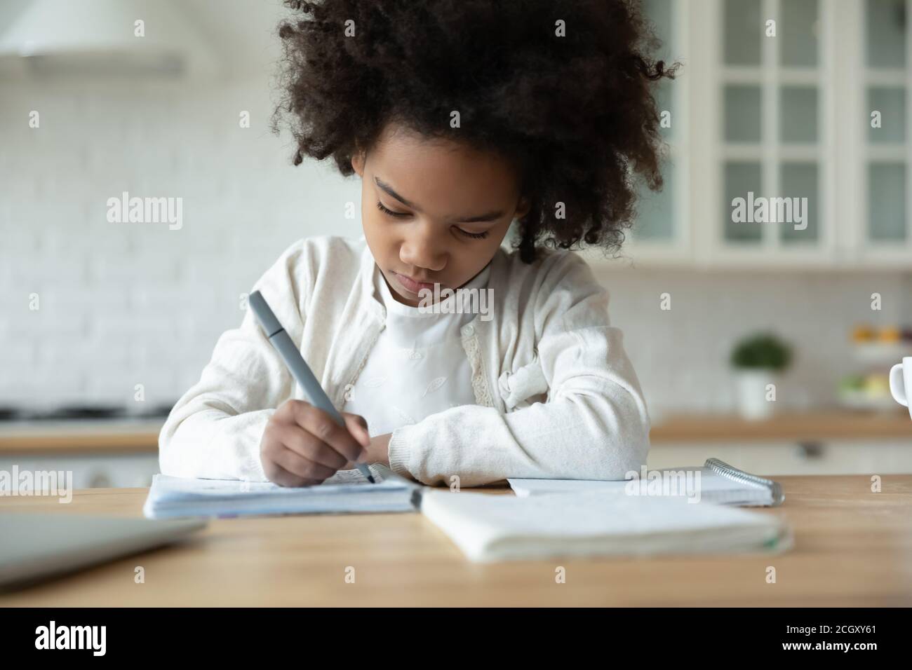 African american child girl handwriting school tasks alone at home ...