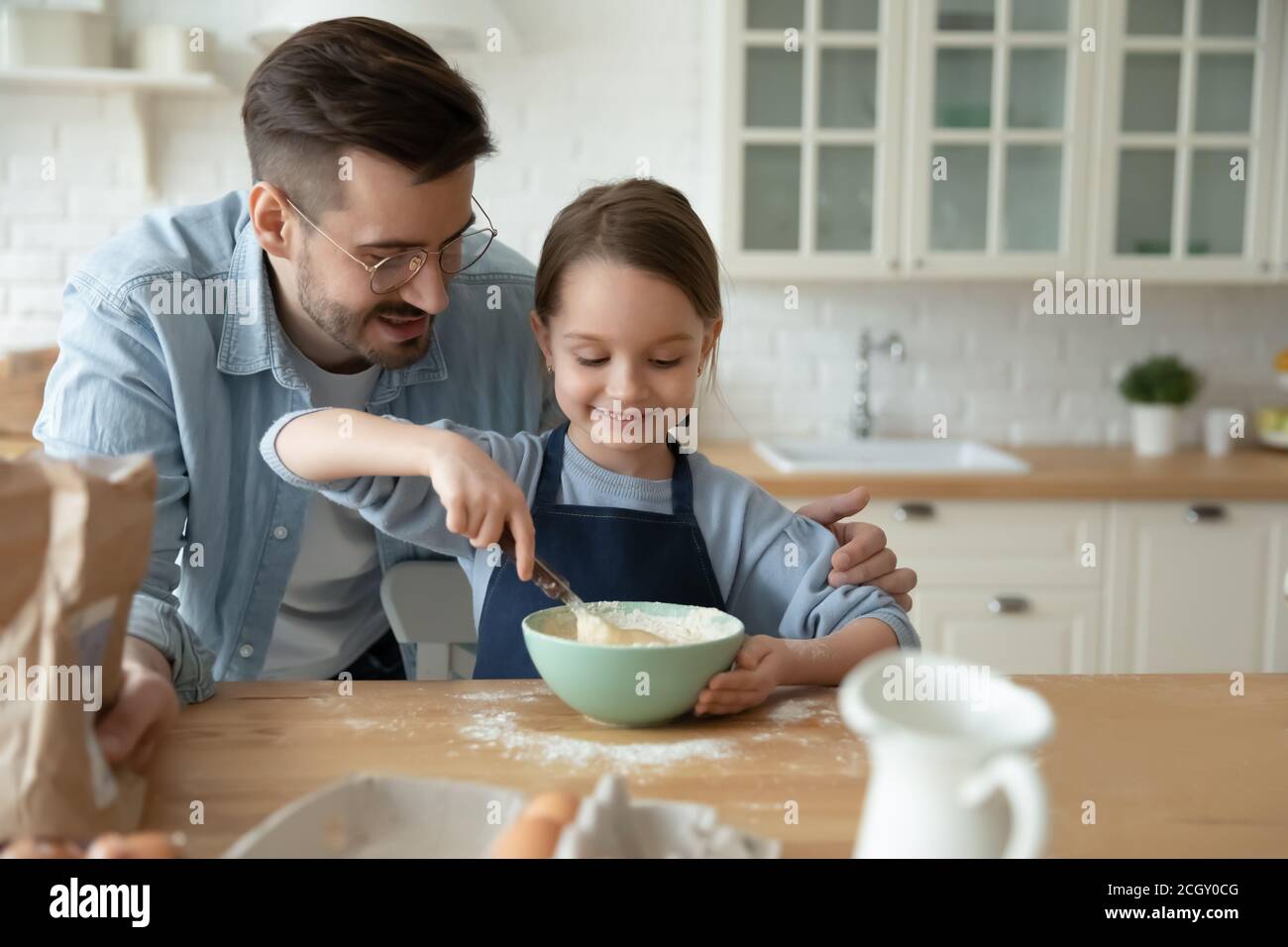 Caring young father helping small daughter preparing food Stock Photo ... Caring young father helping small daughter preparing food Stock Photo ...
