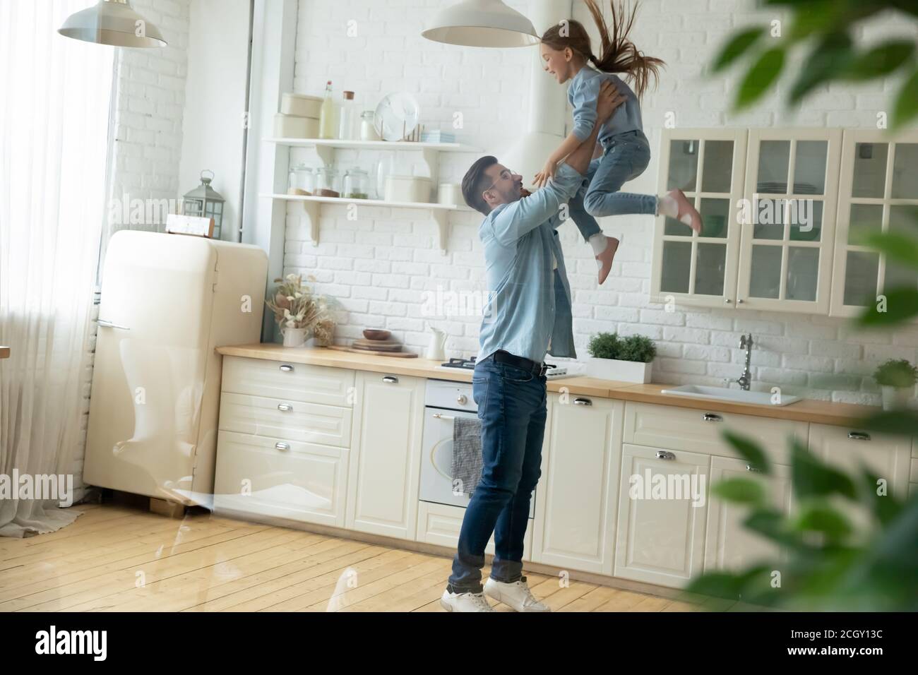 Happy young man lifting in air small preschool child daughter Stock ...
