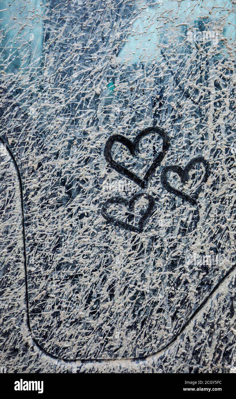 Three hearts drawn to window grime layer of dried grey mud Stock Photo ...