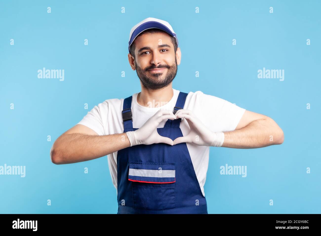 Love our customers! Handyman in overalls and hygiene gloves showing ...