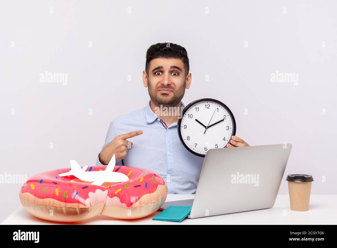 Time to rest! Upset man showing clock, looking frustrated tired at ...