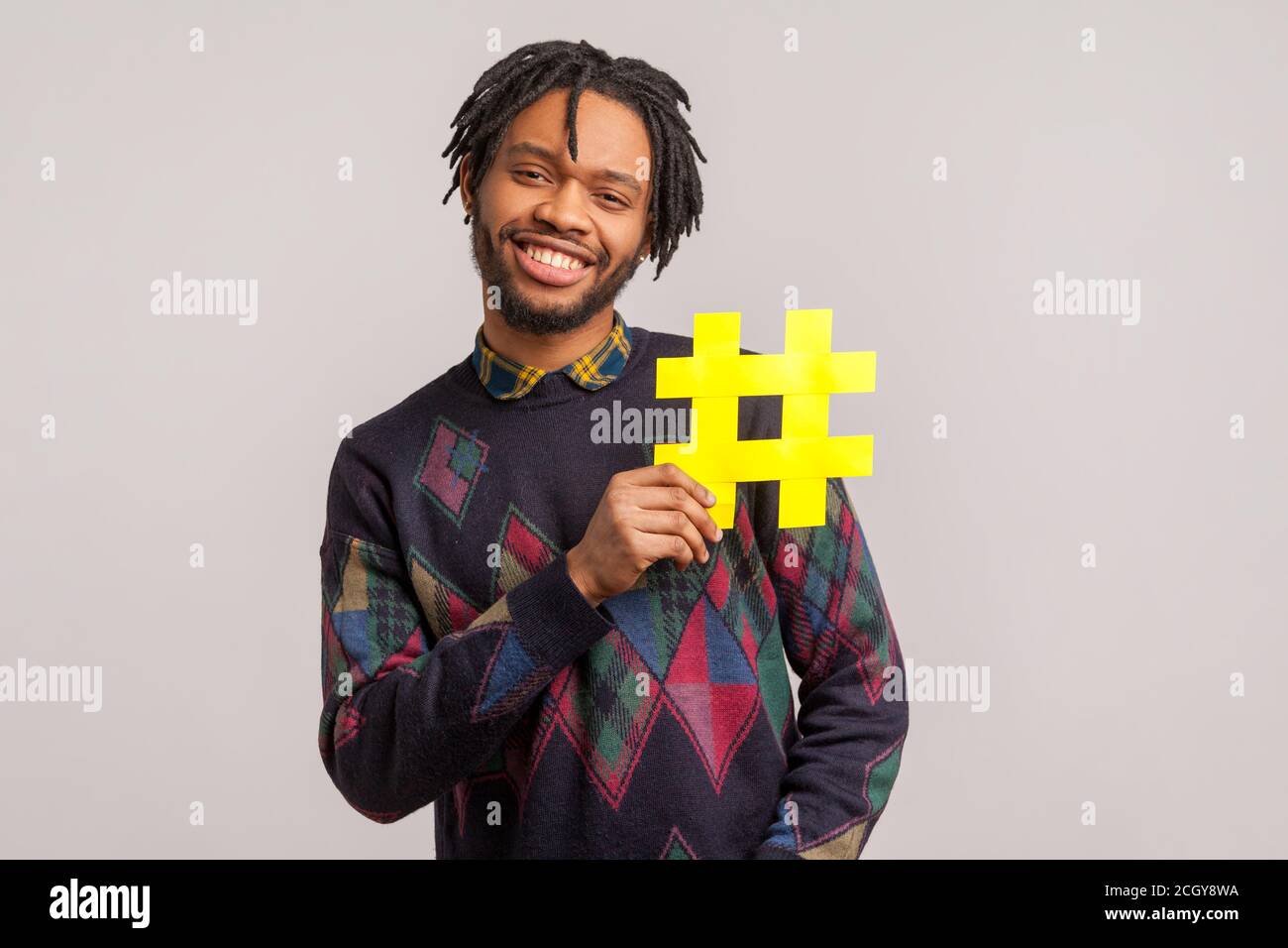 African man with dreadlocks and toothy smile on his face holding ...