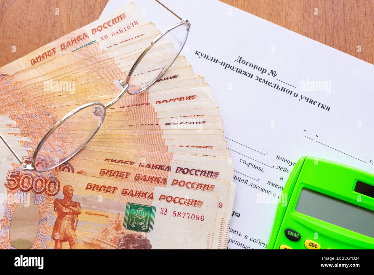 On the table there is a contract for the sale of a land plot, a bundle ...