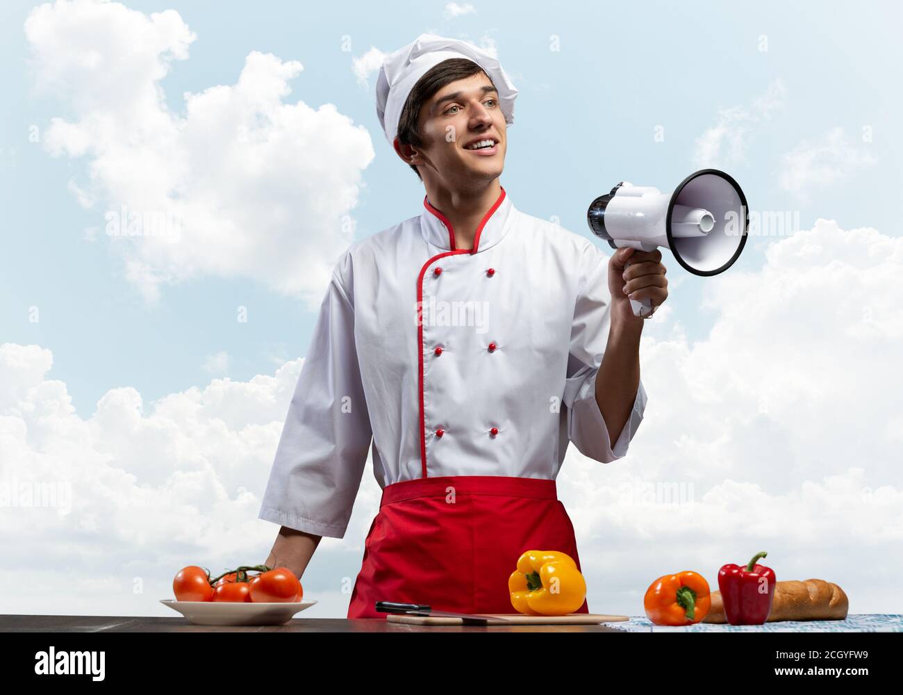 Young chef standing with megaphone in hand Stock Photo - Alamy